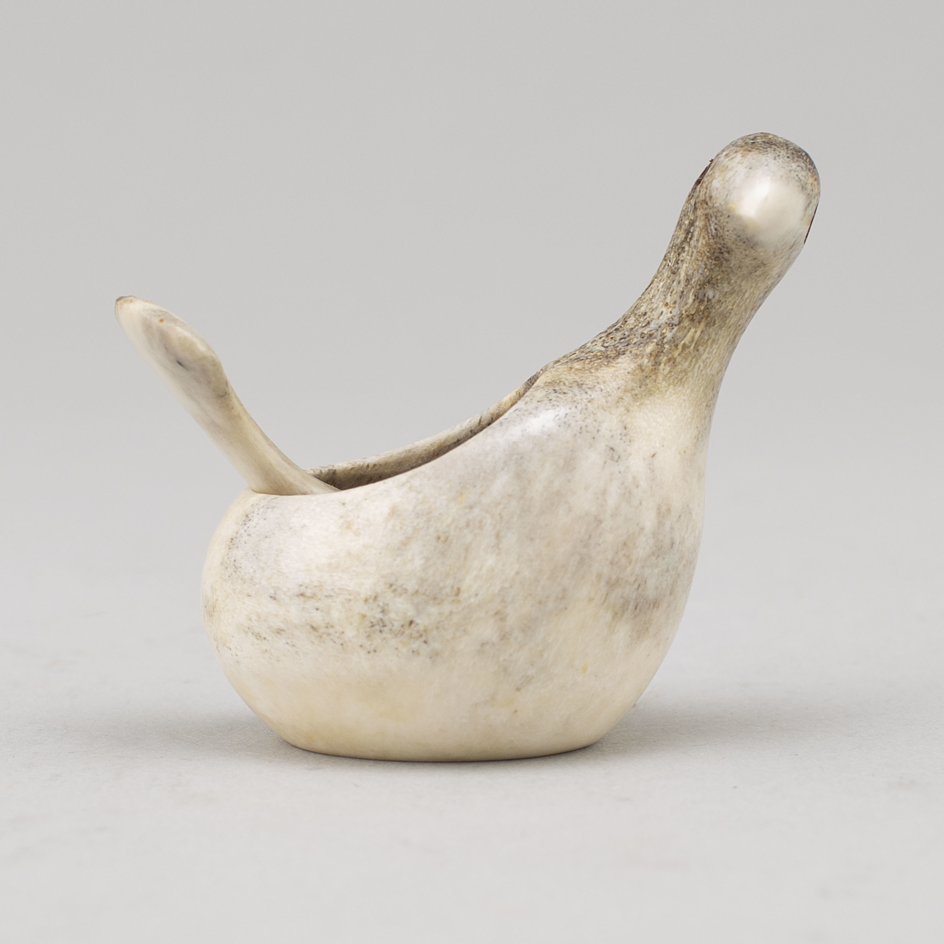 LARS PIRAK, a reindeer horn salt cellar and spoon, signed Lars Pirak ...