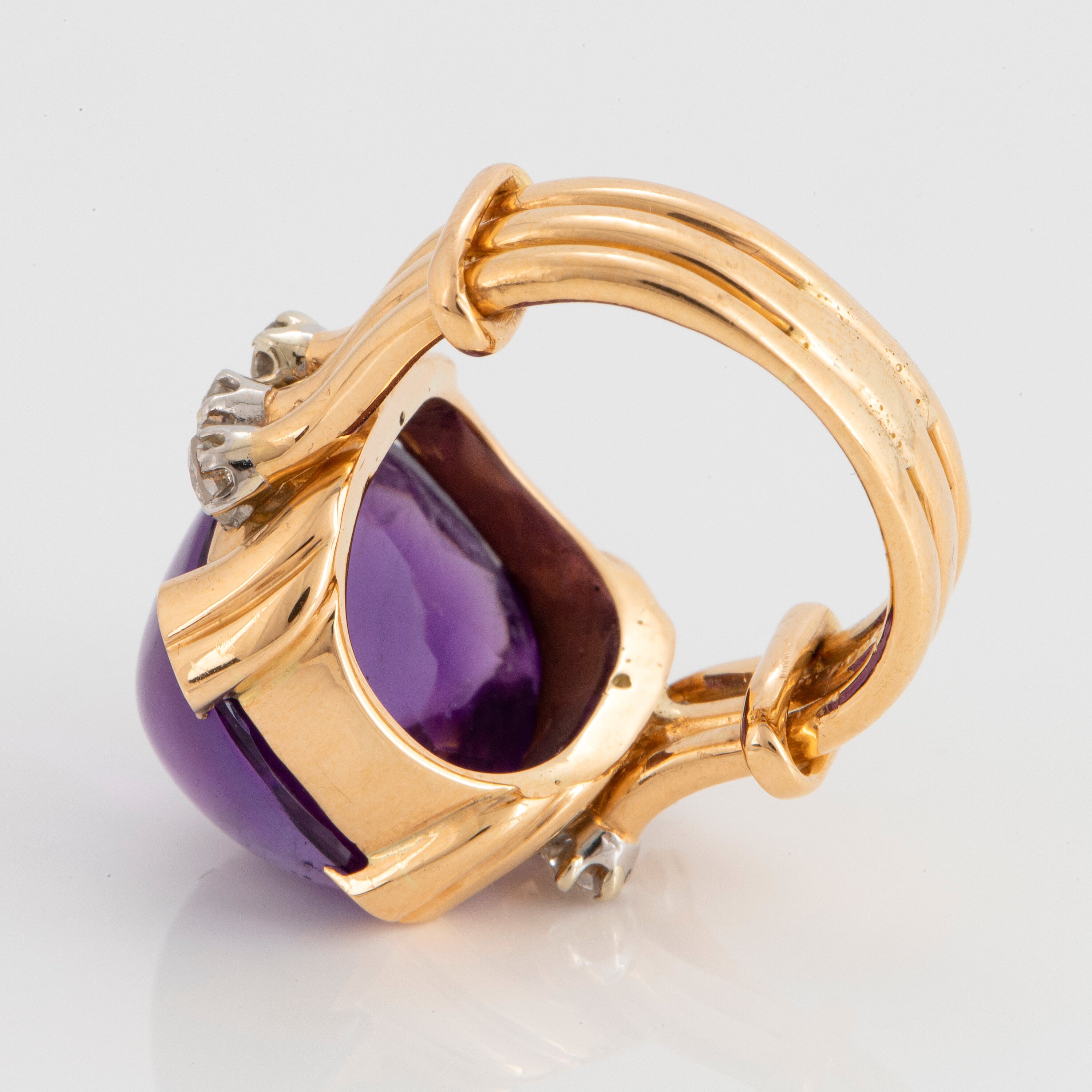 A WA Bolin ring in 18K gold set with a cabochon-cut amethyst and round ...