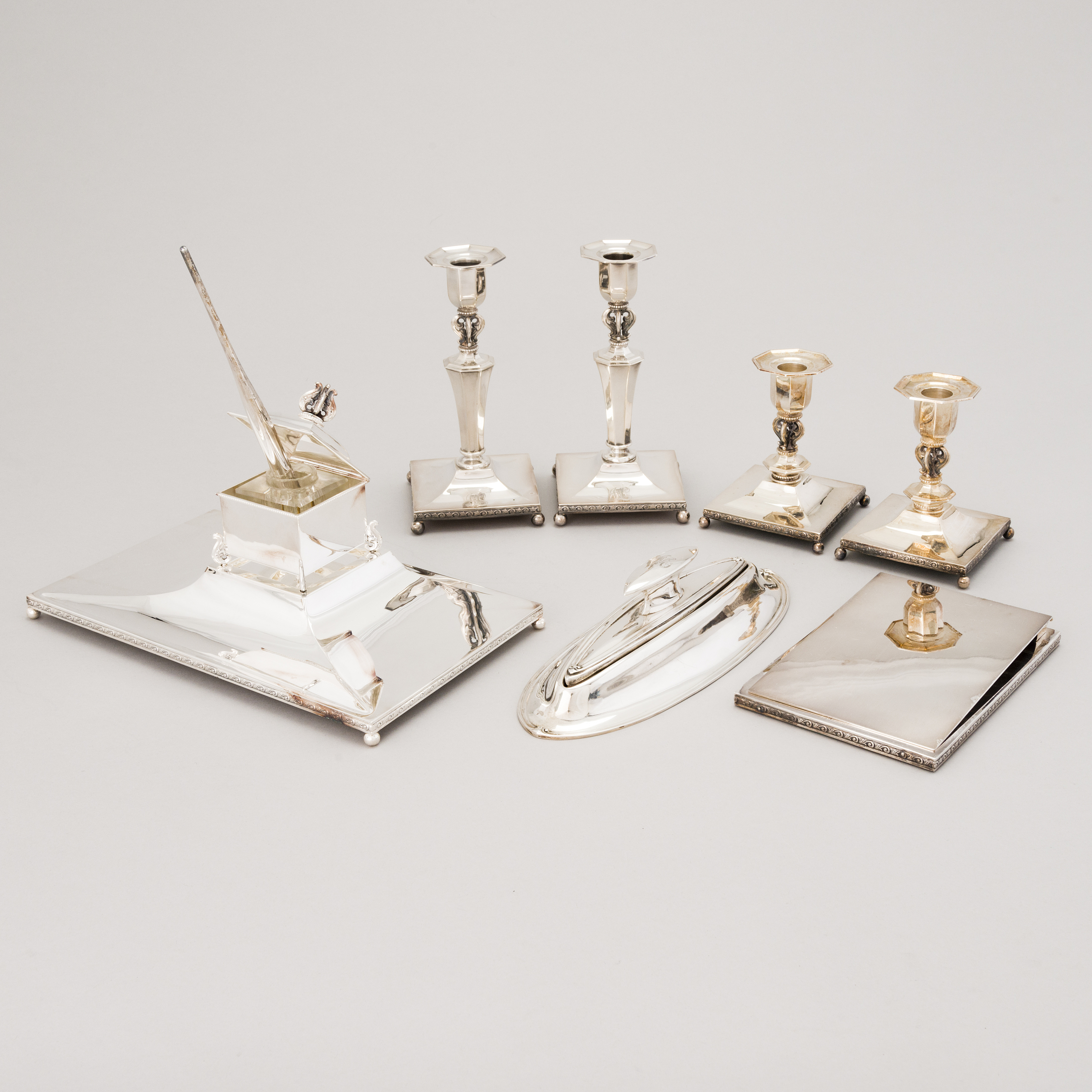 Four silver writing desk utensils and two pair of silver candlesticks ...