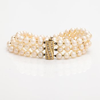 A three-stranded pearl bracelet with cultured pearls, 14K gold and ...
