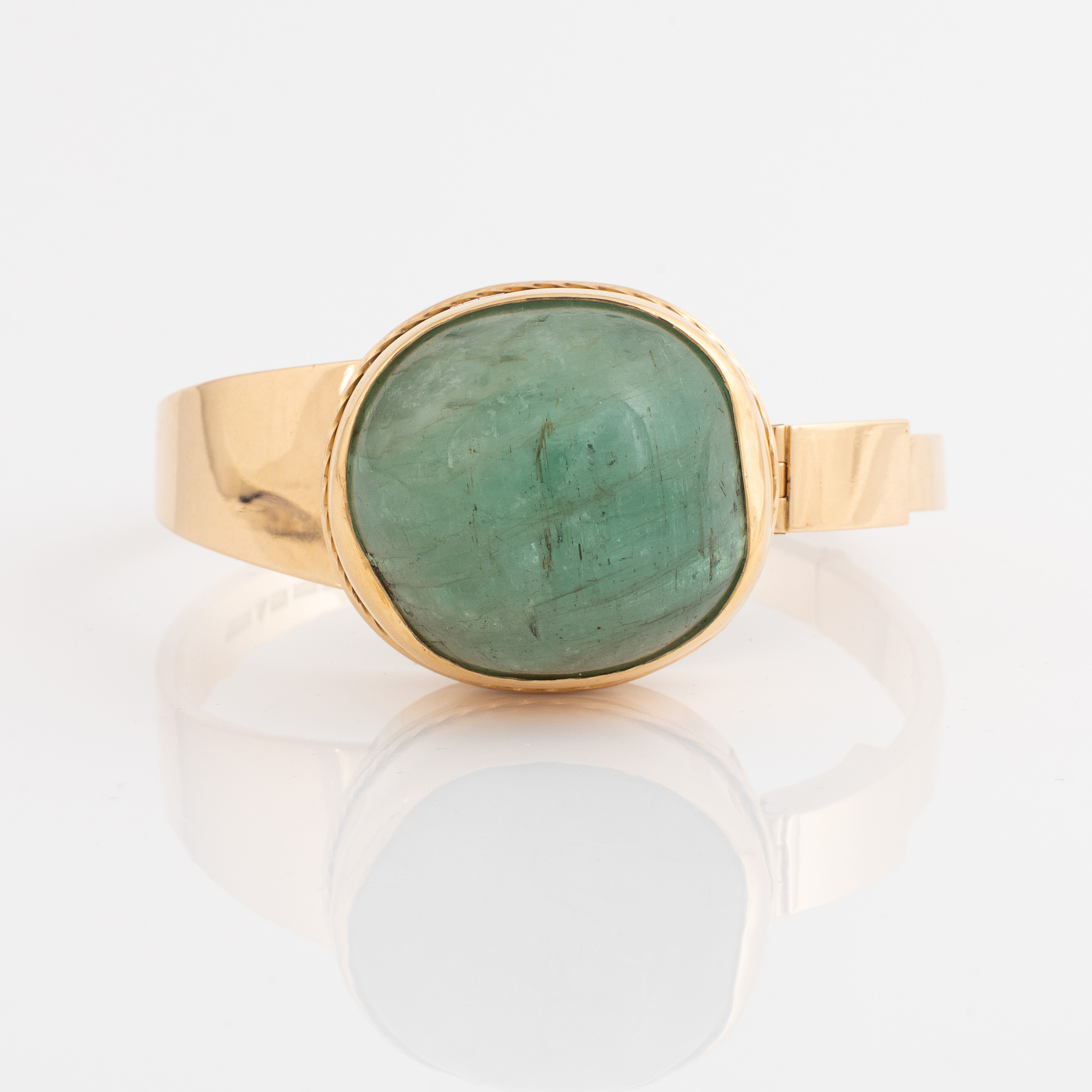 Armring 18K guld med en cabochonslipad smaragd. - Bukowskis