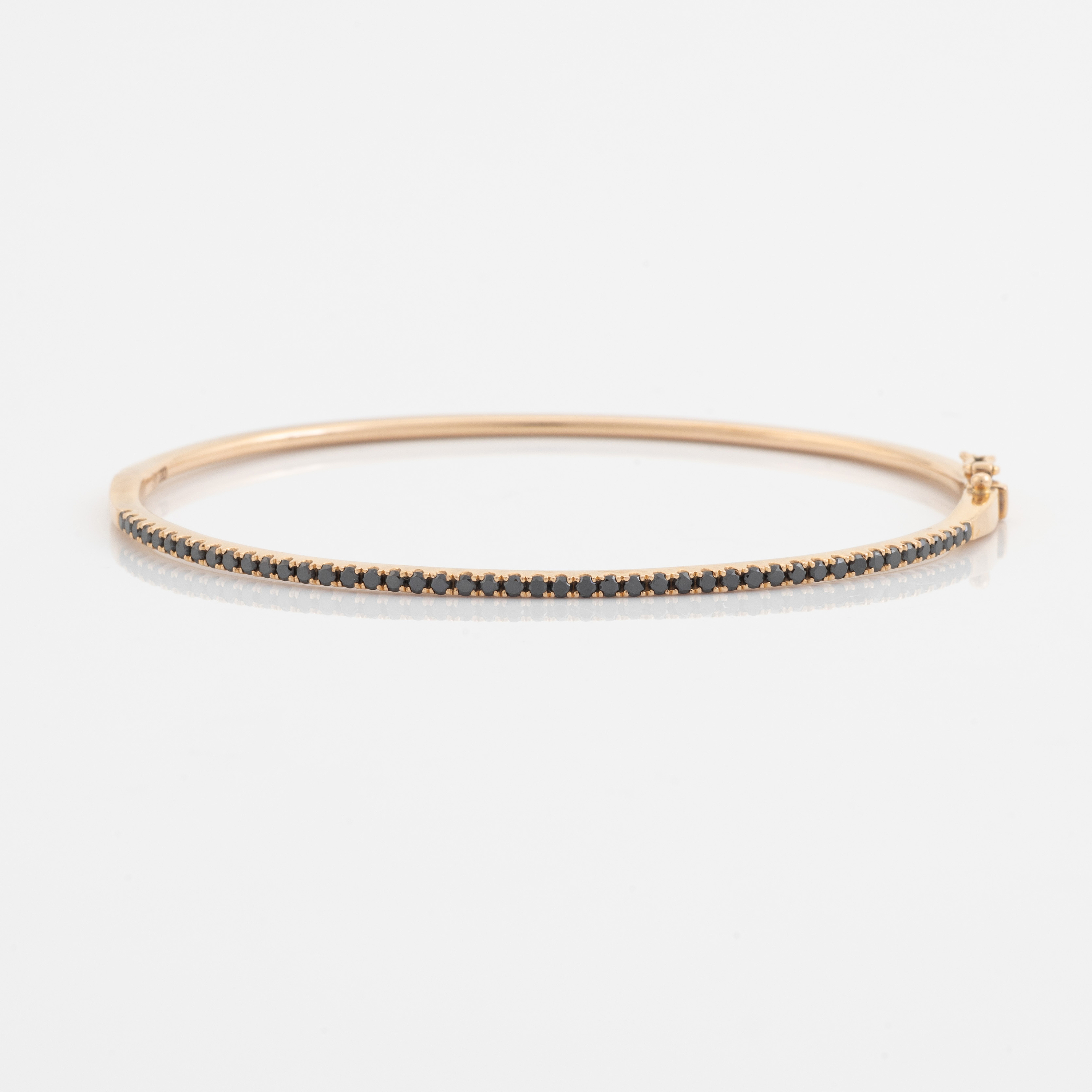 An 18K rose gold bangle set with round brilliant-cut black diamonds ...