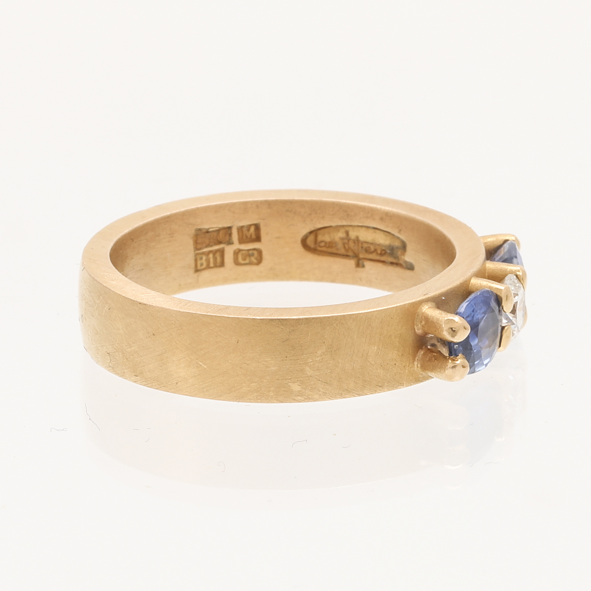A ring containing at least 21.6K gold, set with a round cut brilliant ...