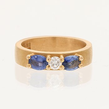 A ring containing at least 21.6K gold, set with a round cut brilliant ...