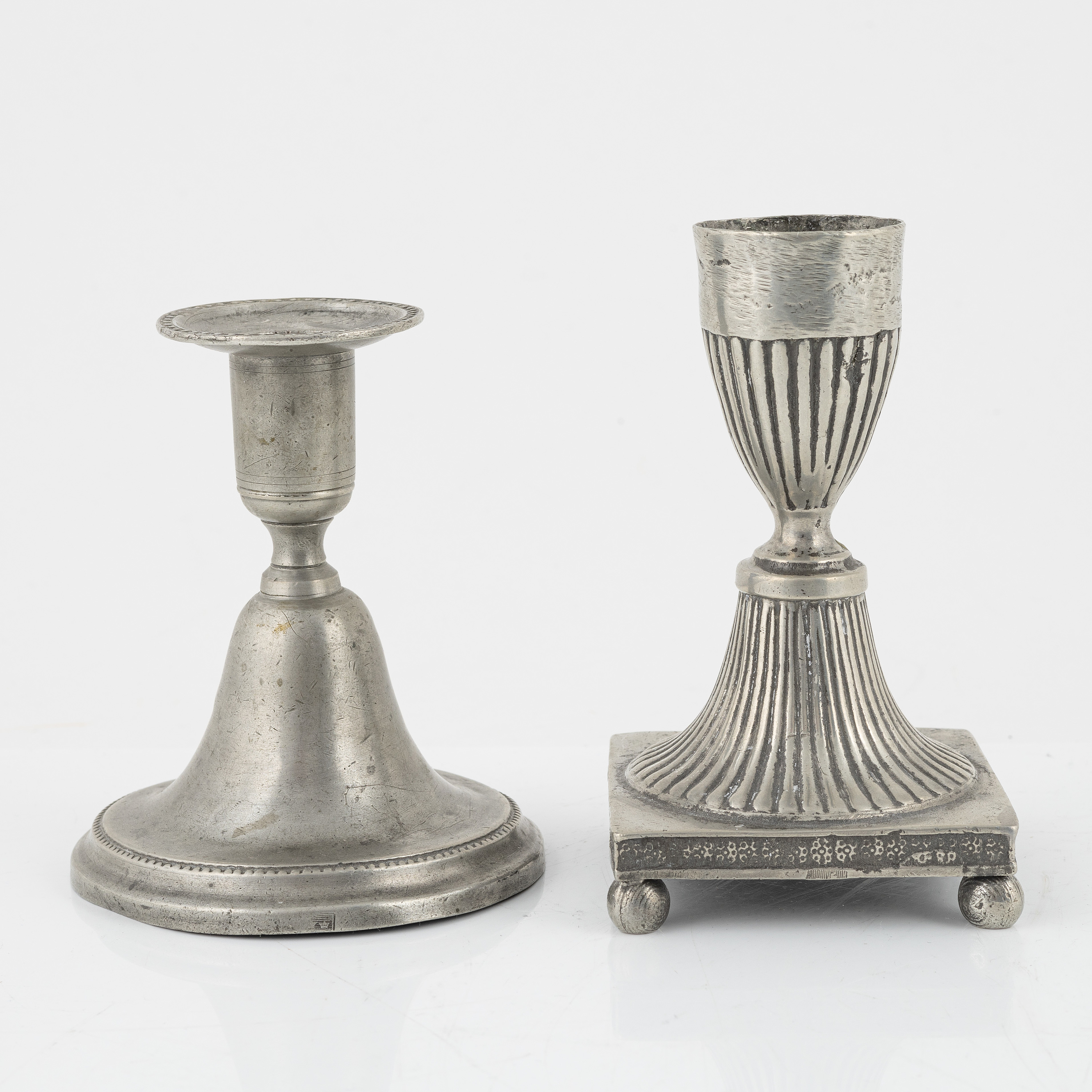 A group of three pewter candlesticks, a salt cellar and four dishes ...