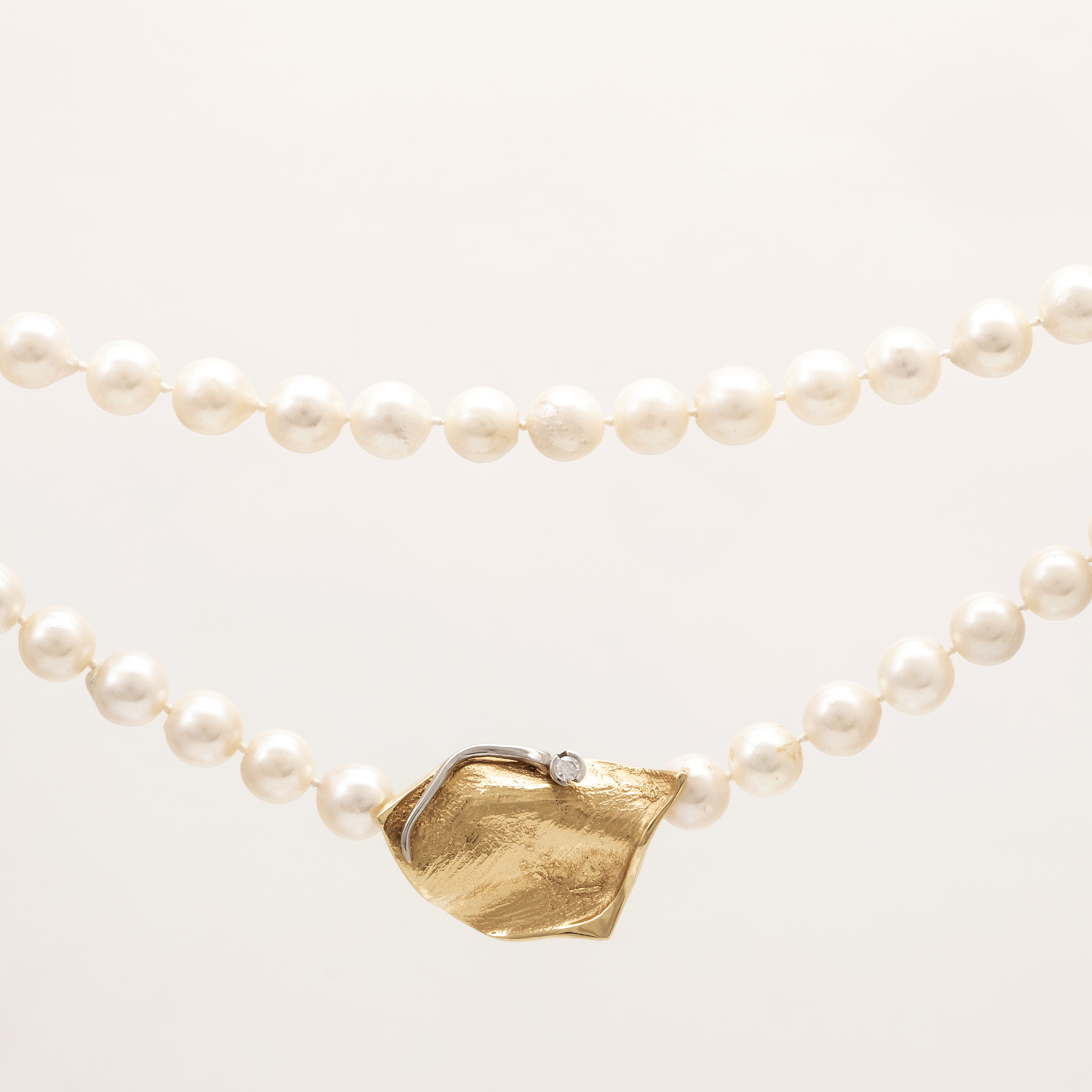 A necklace of cultured pearls, lock in 18K white and red gold set with ...