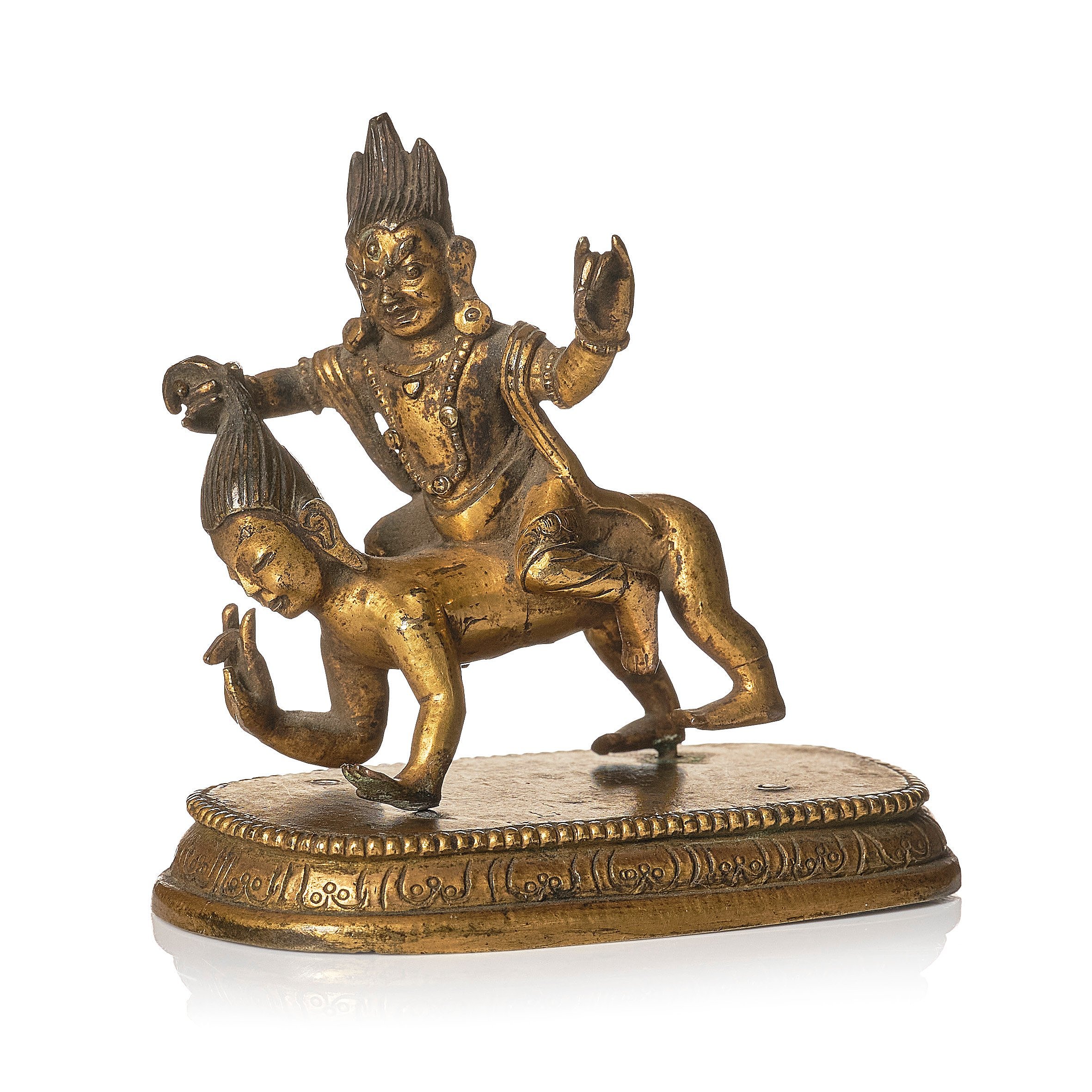A small gilt bronze figure wrathful deity riding on a corpse, Tibeto ...