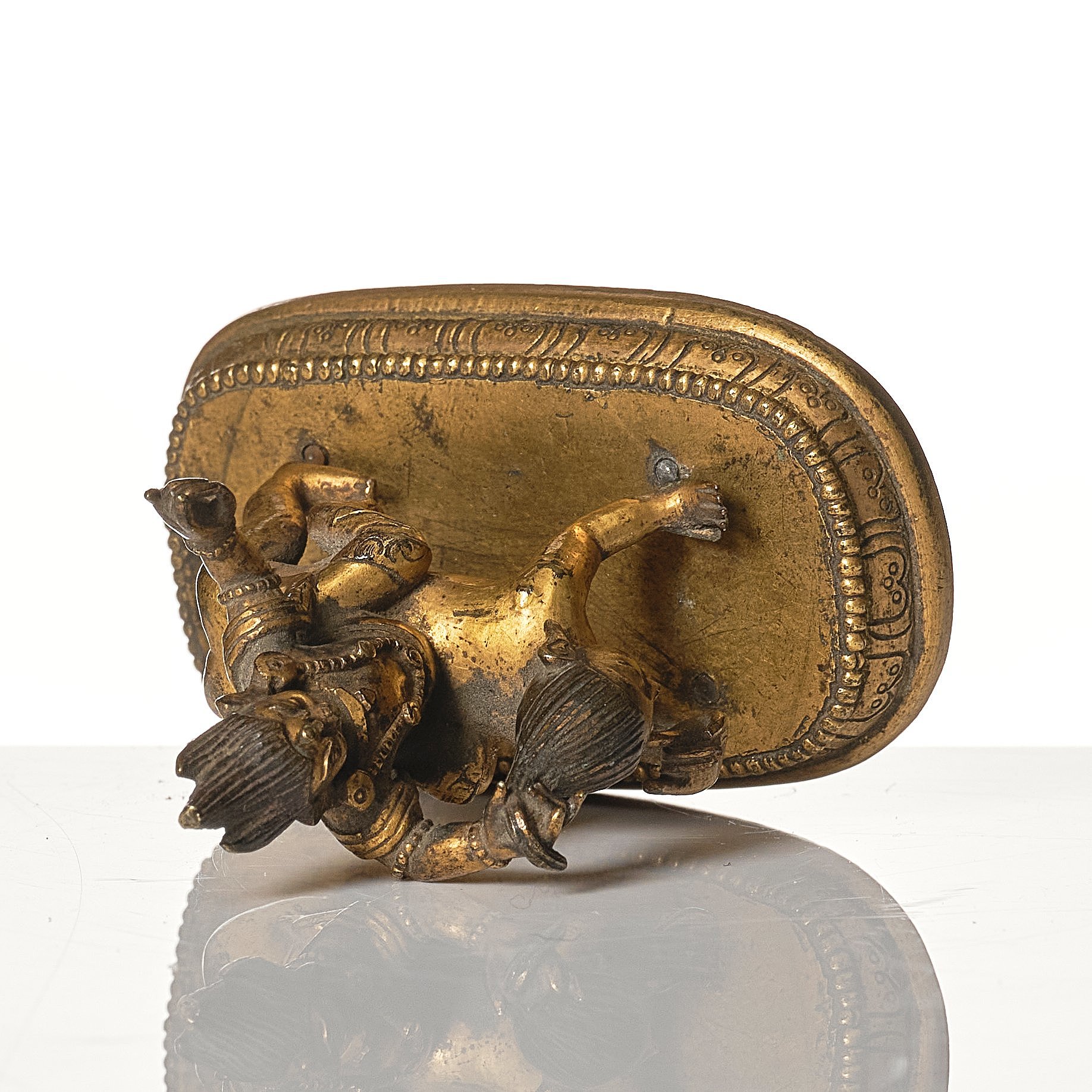 A small gilt bronze figure wrathful deity riding on a corpse, Tibeto ...