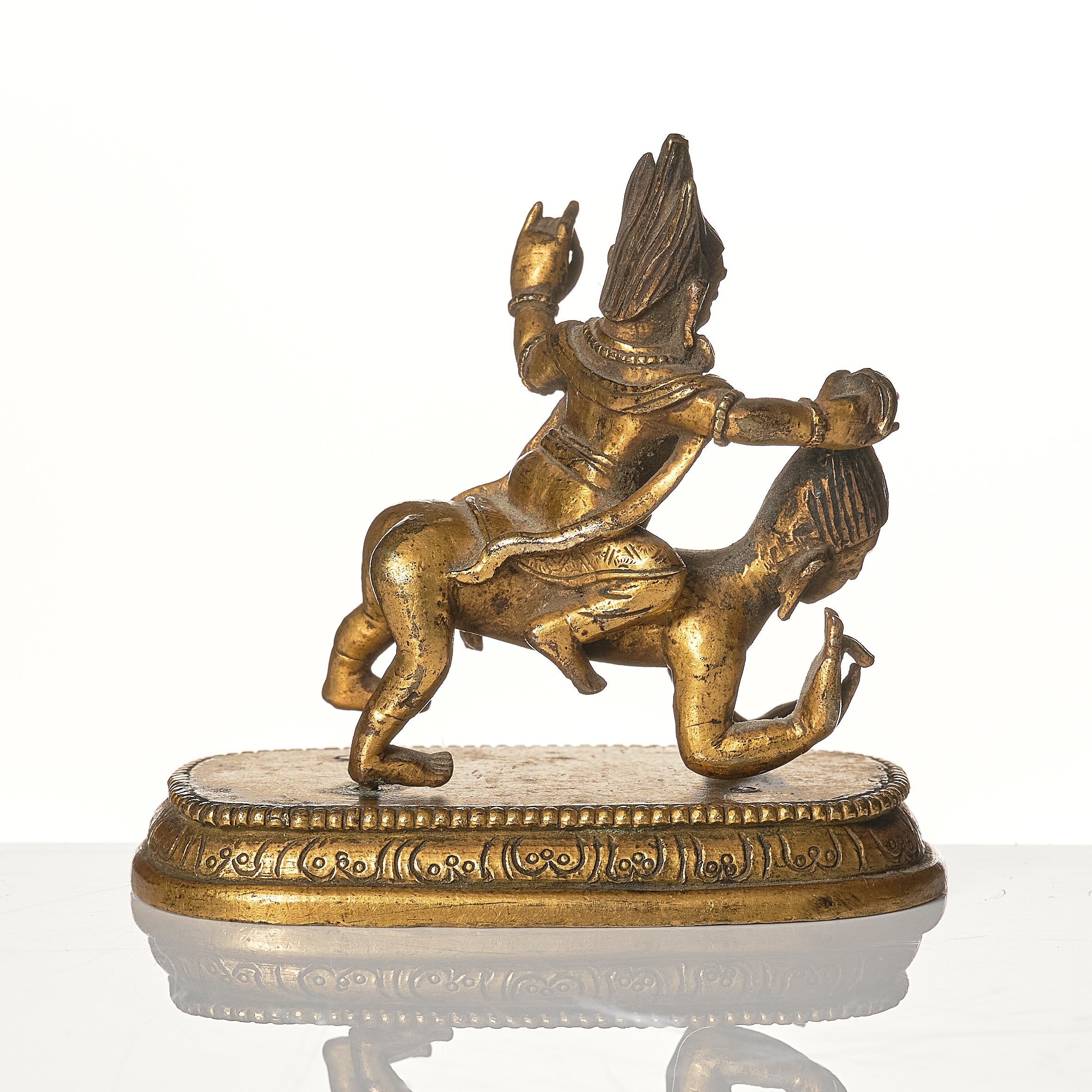 A small gilt bronze figure wrathful deity riding on a corpse, Tibeto ...