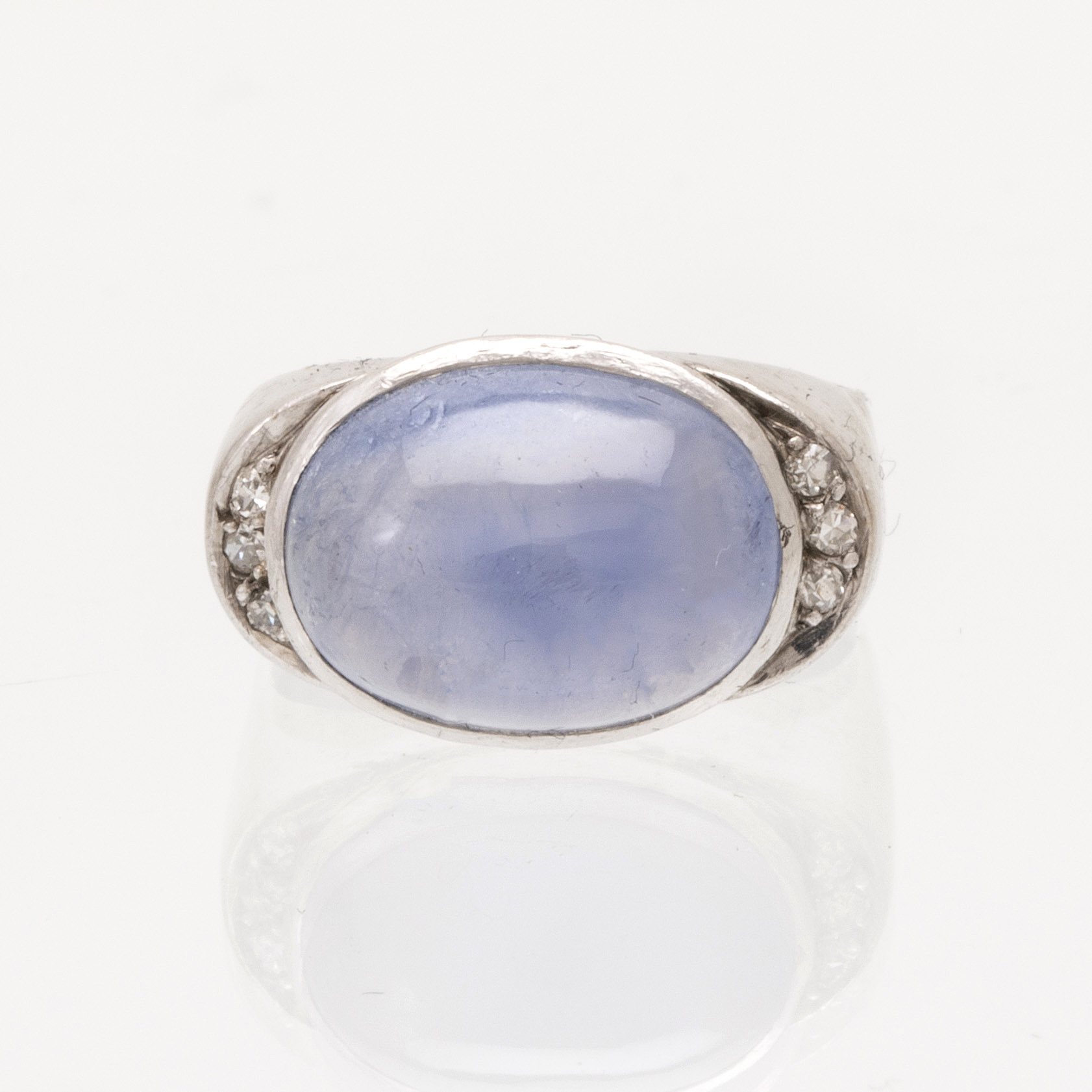 An 18K white gold ring set with single cut diamonds and an oval ...