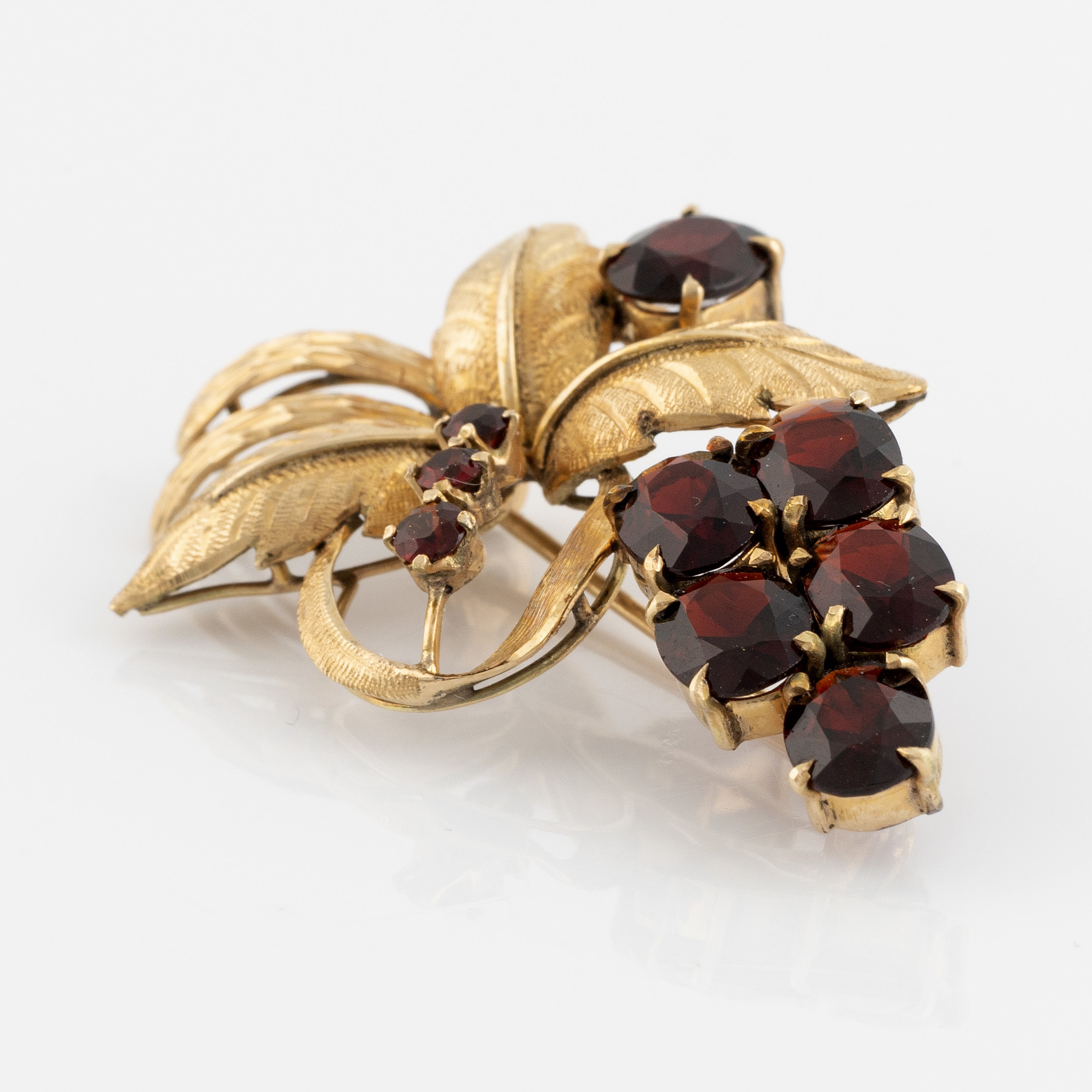 Brosch, guld med granater. - Bukowskis