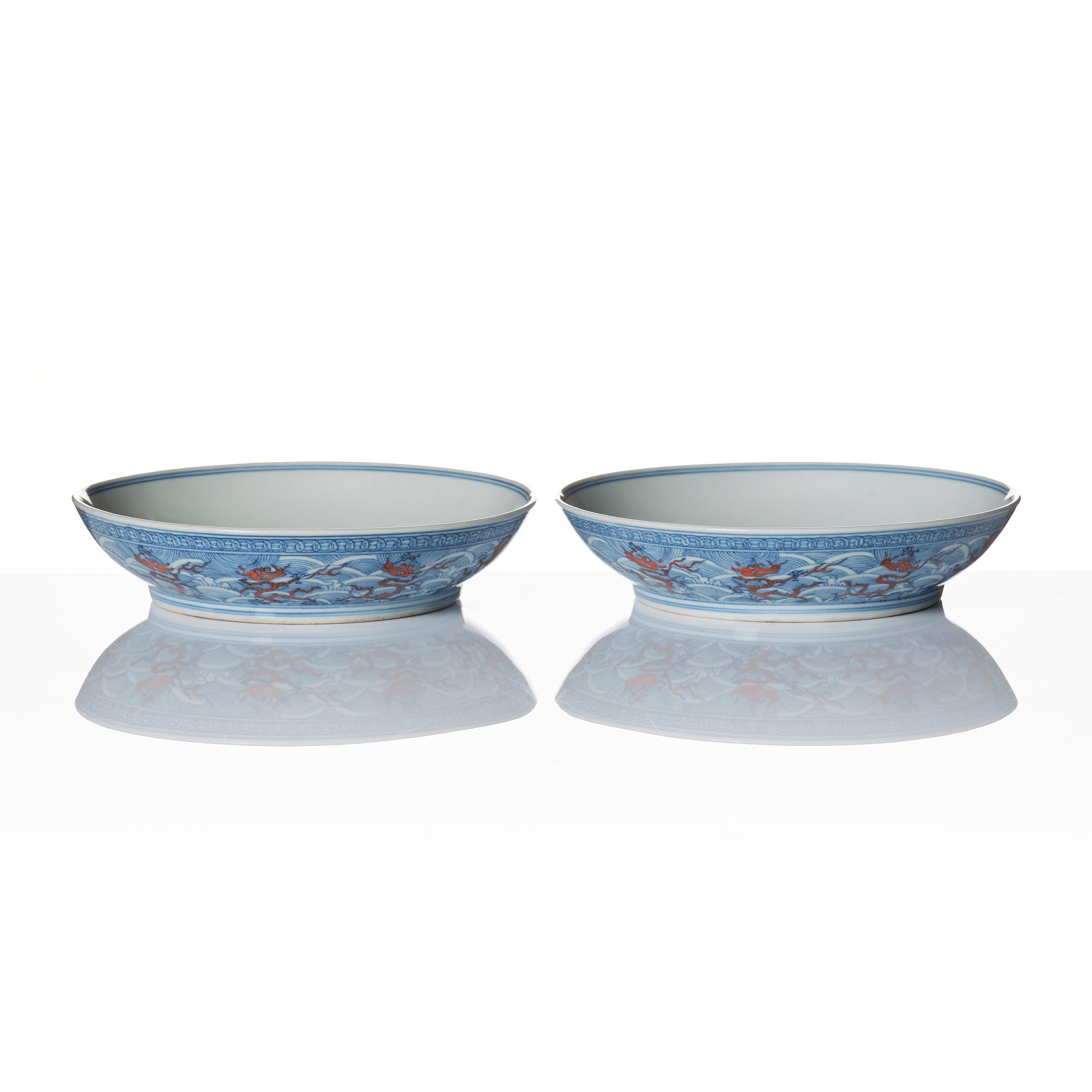 A pair of blue and white and iron red decorated dragon dishes, Qing ...