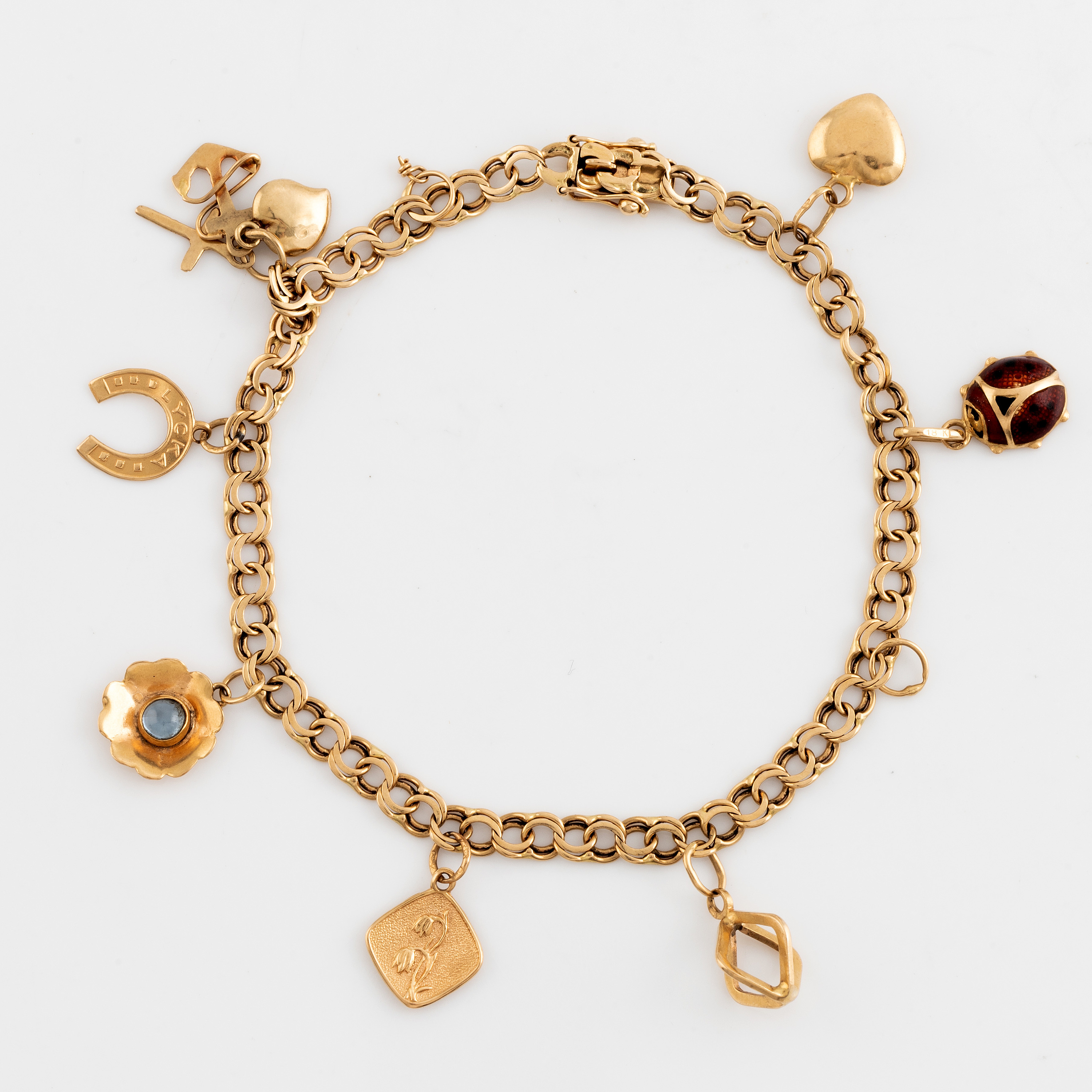 18K gold bracelet, with charms. - Bukowskis