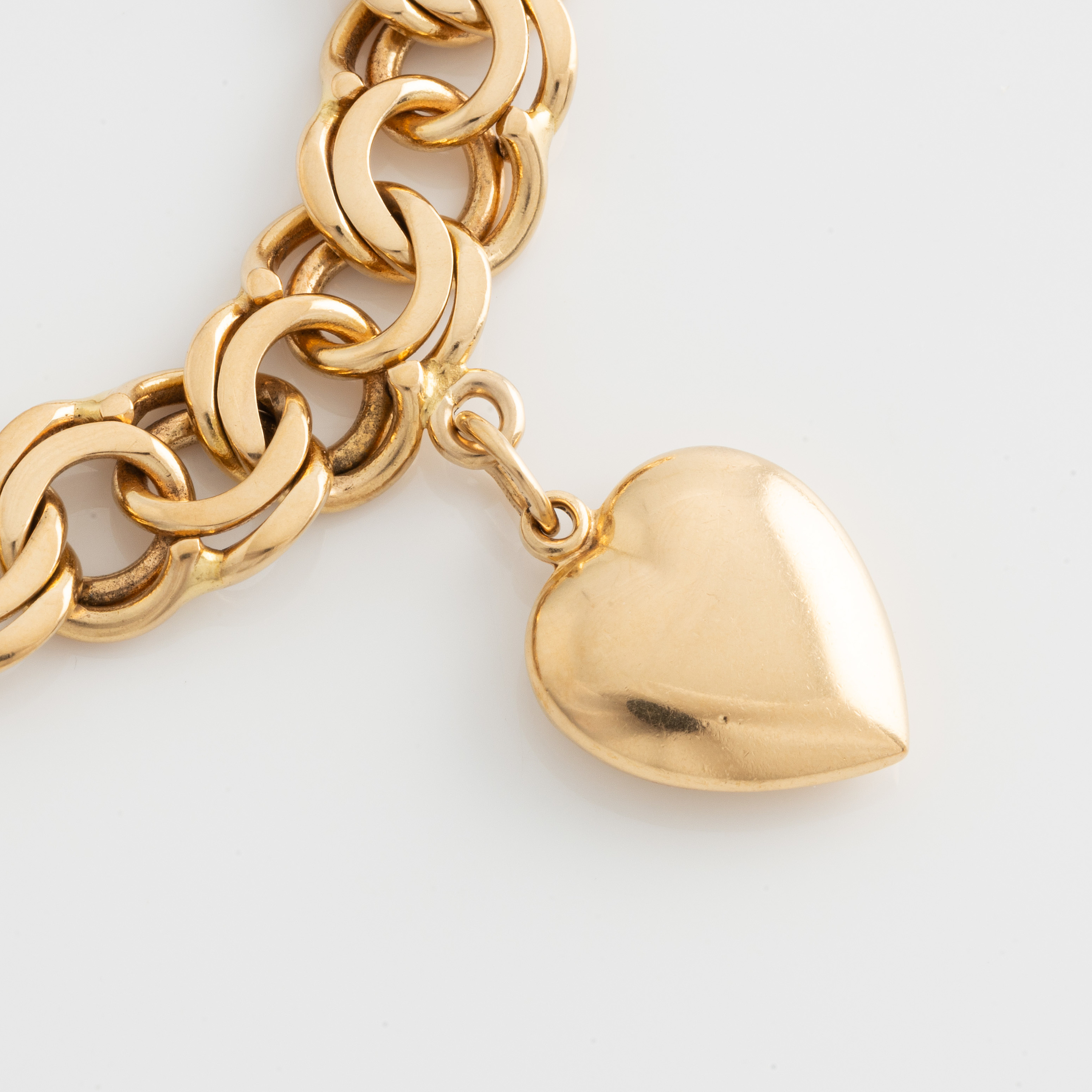 An 18K gold charm bracelet, one charm set with round brilliant-cut ...