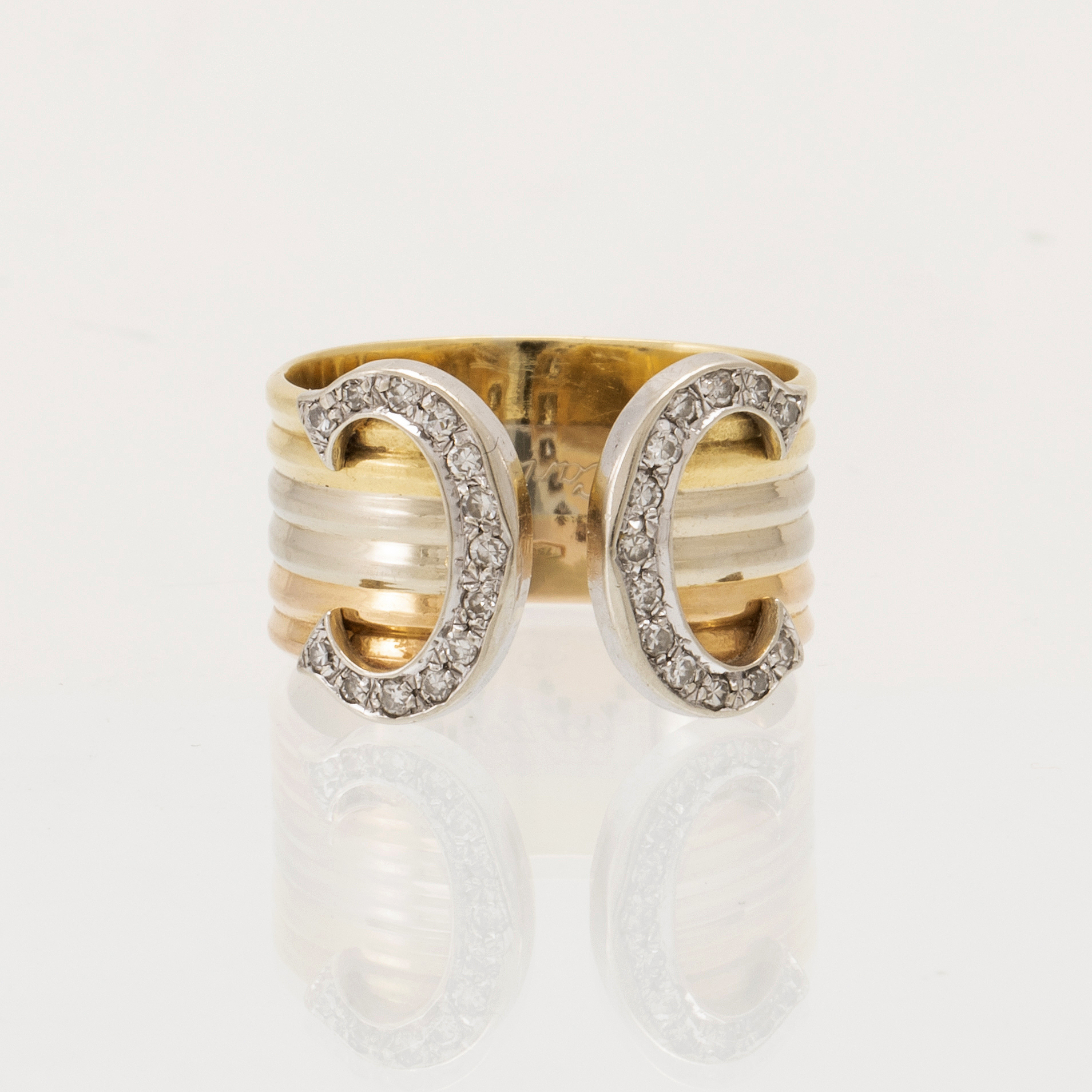 A Cartier "Double C" ring 18K tricolor gold set with round single-cut ...