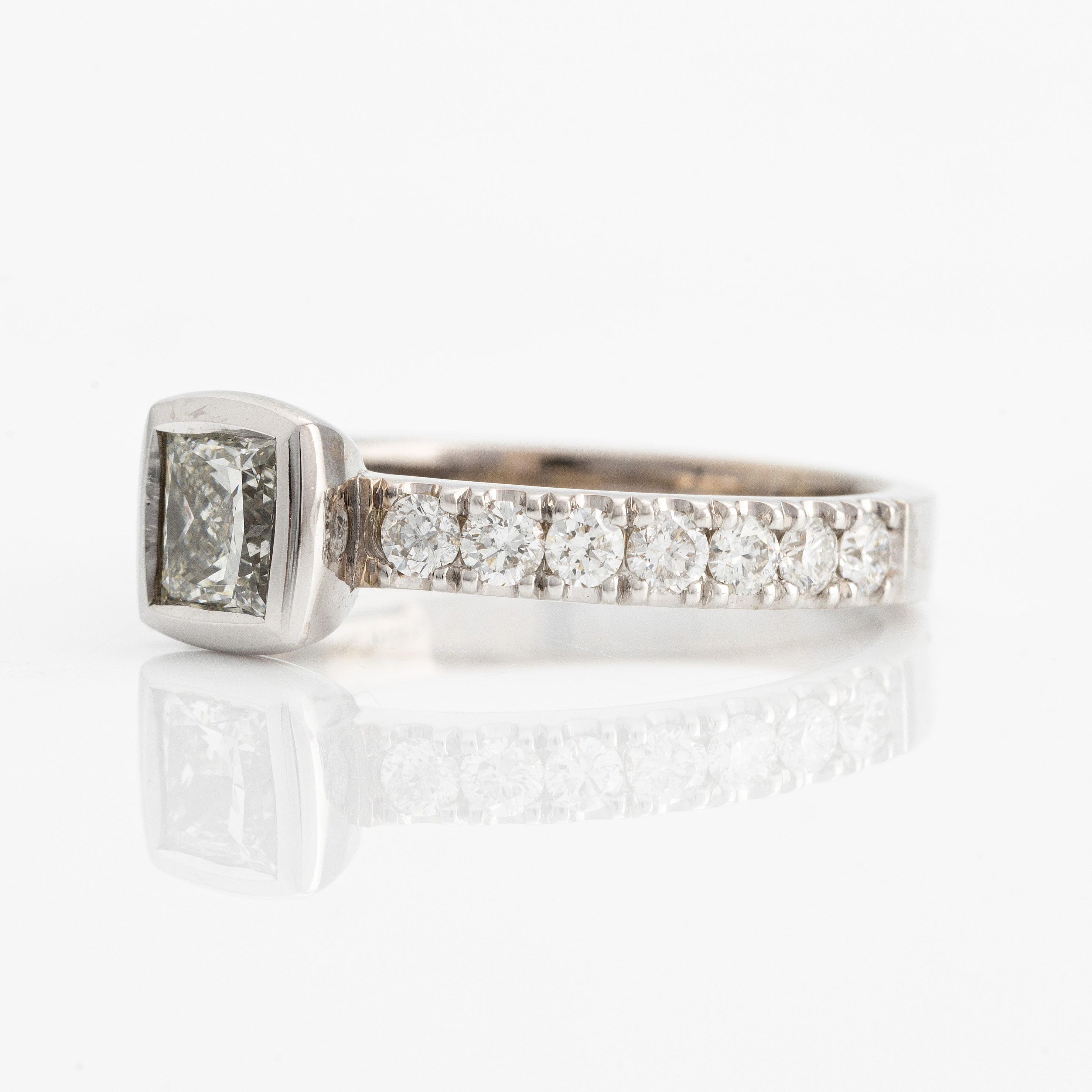 Ring 14K guld med en prinsesslipad diamant samt runda briljantslipade diamanter. - Bukowskis