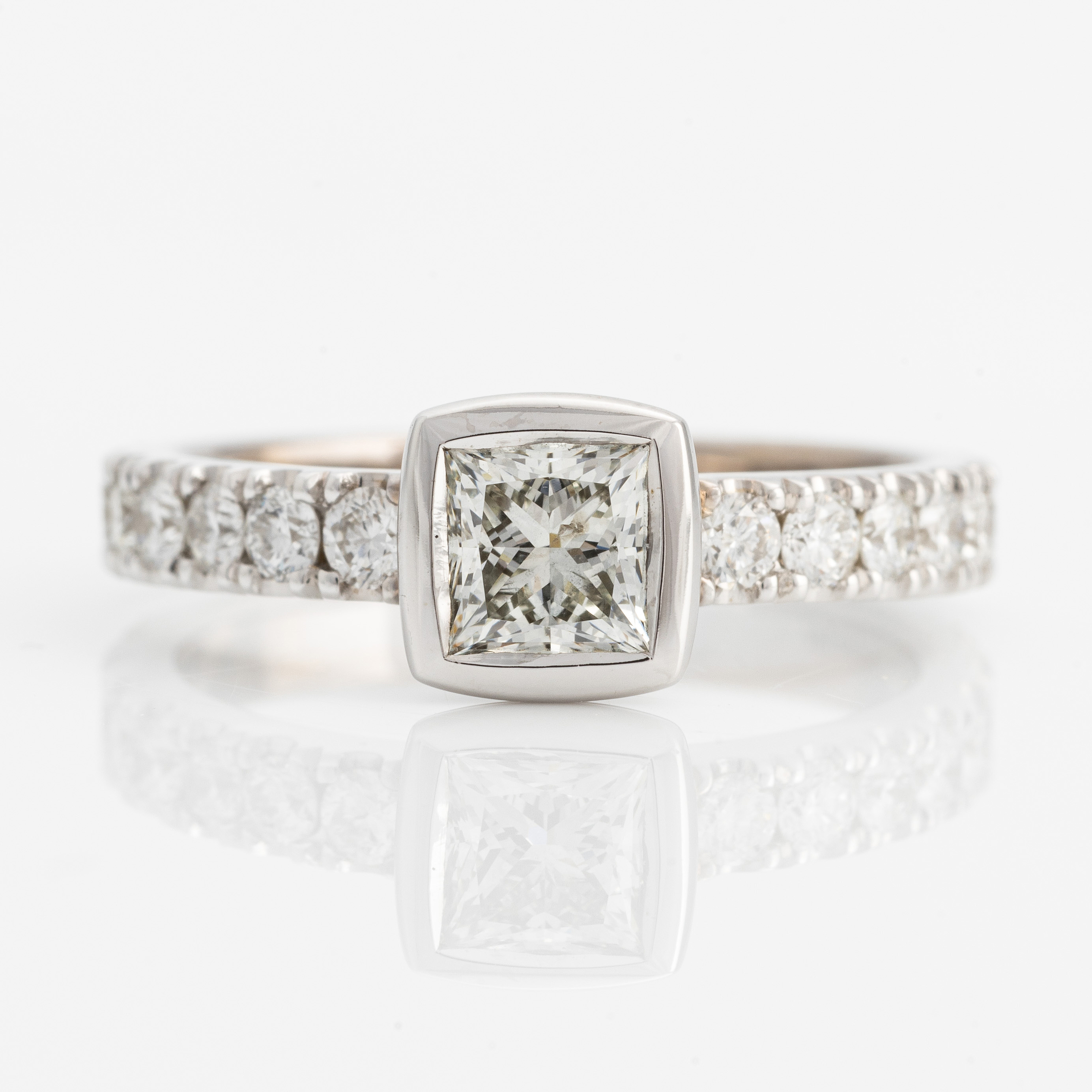 Ring 14K guld med en prinsesslipad diamant samt runda briljantslipade diamanter. - Bukowskis