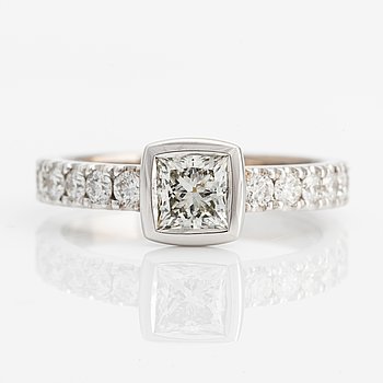 Ring 14K guld med en prinsesslipad diamant samt runda briljantslipade ...