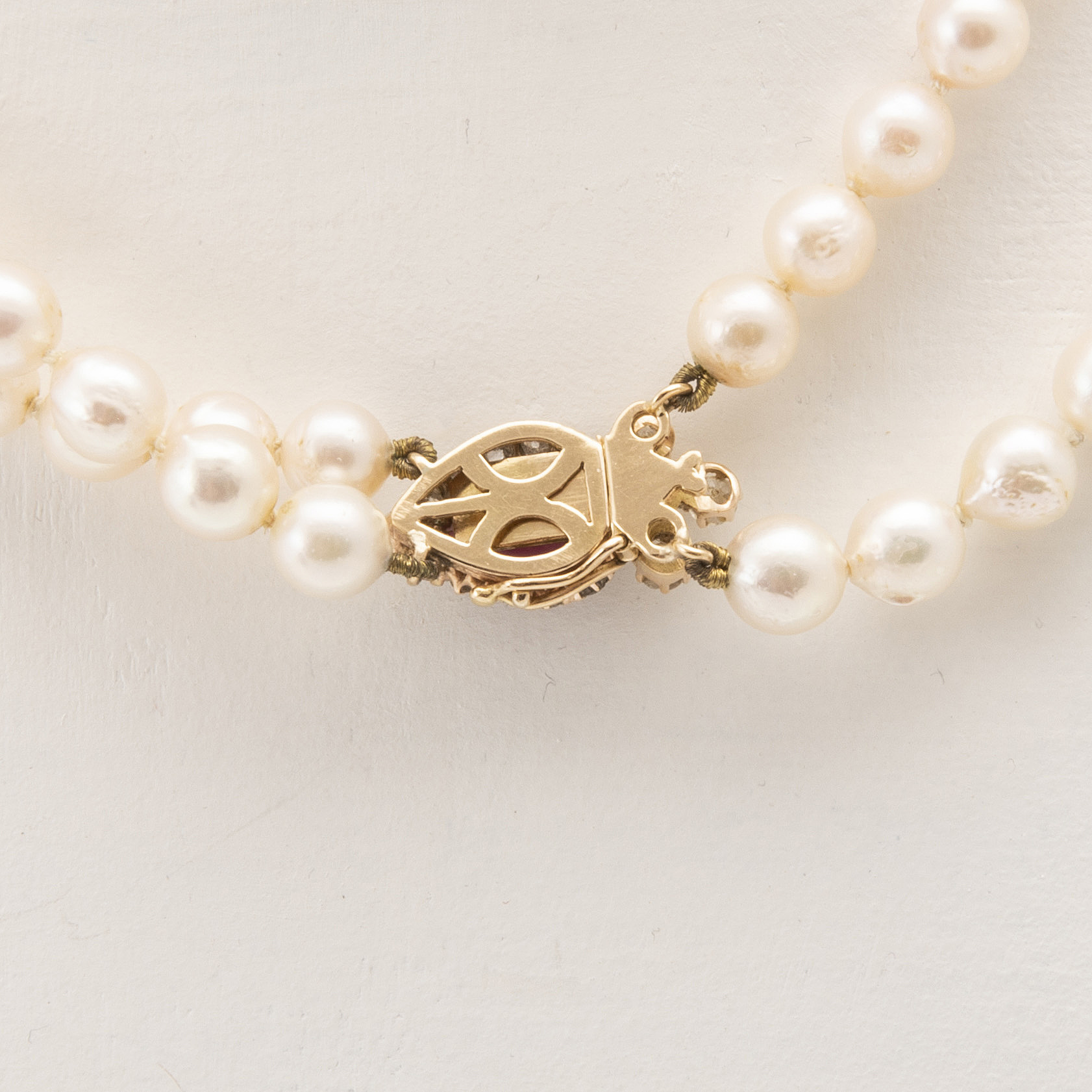 A double-stranded necklace with cultured pearls and an 18K gold clasp ...