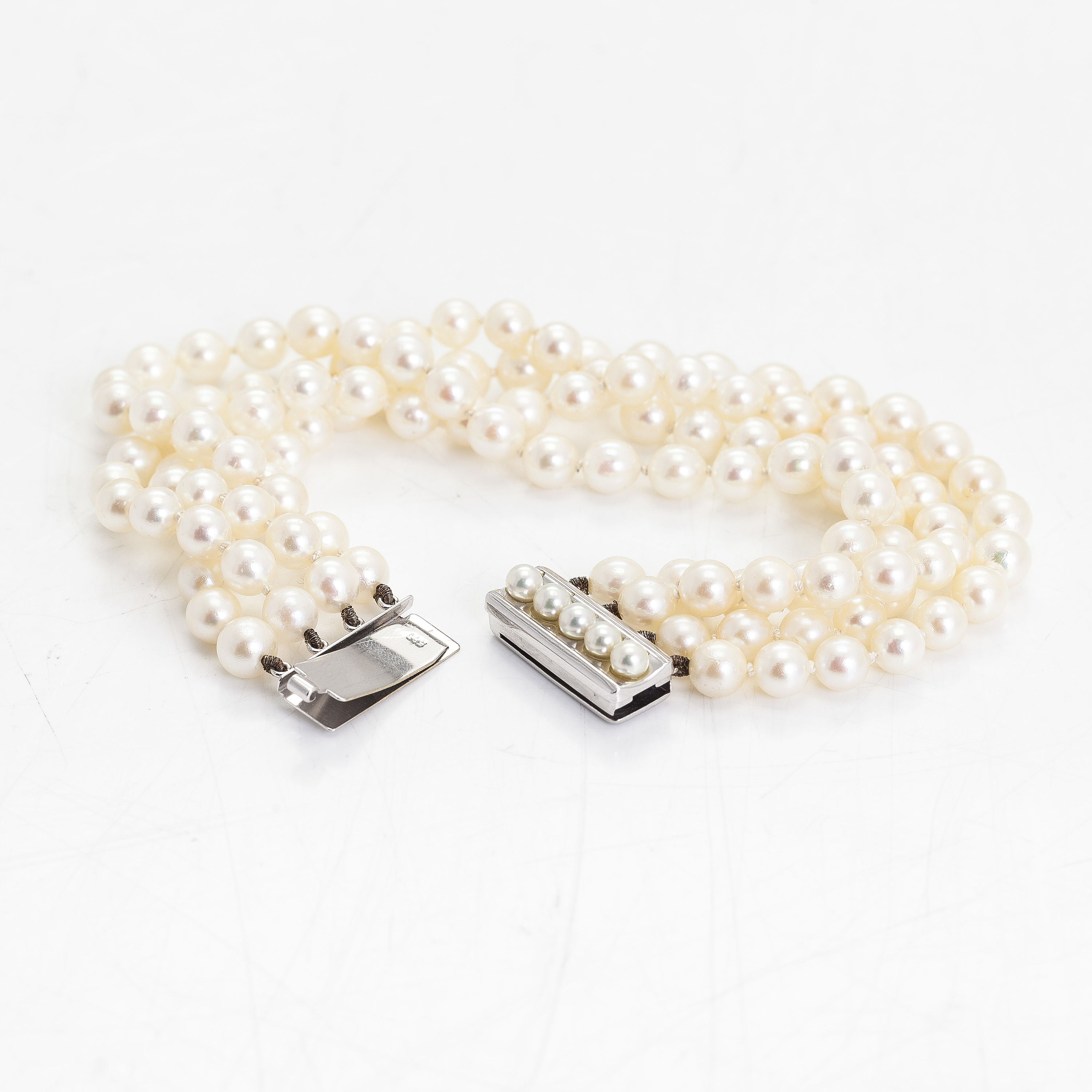 A four-strand bracelet of cultured pearls and clasp in 14K white gold ...