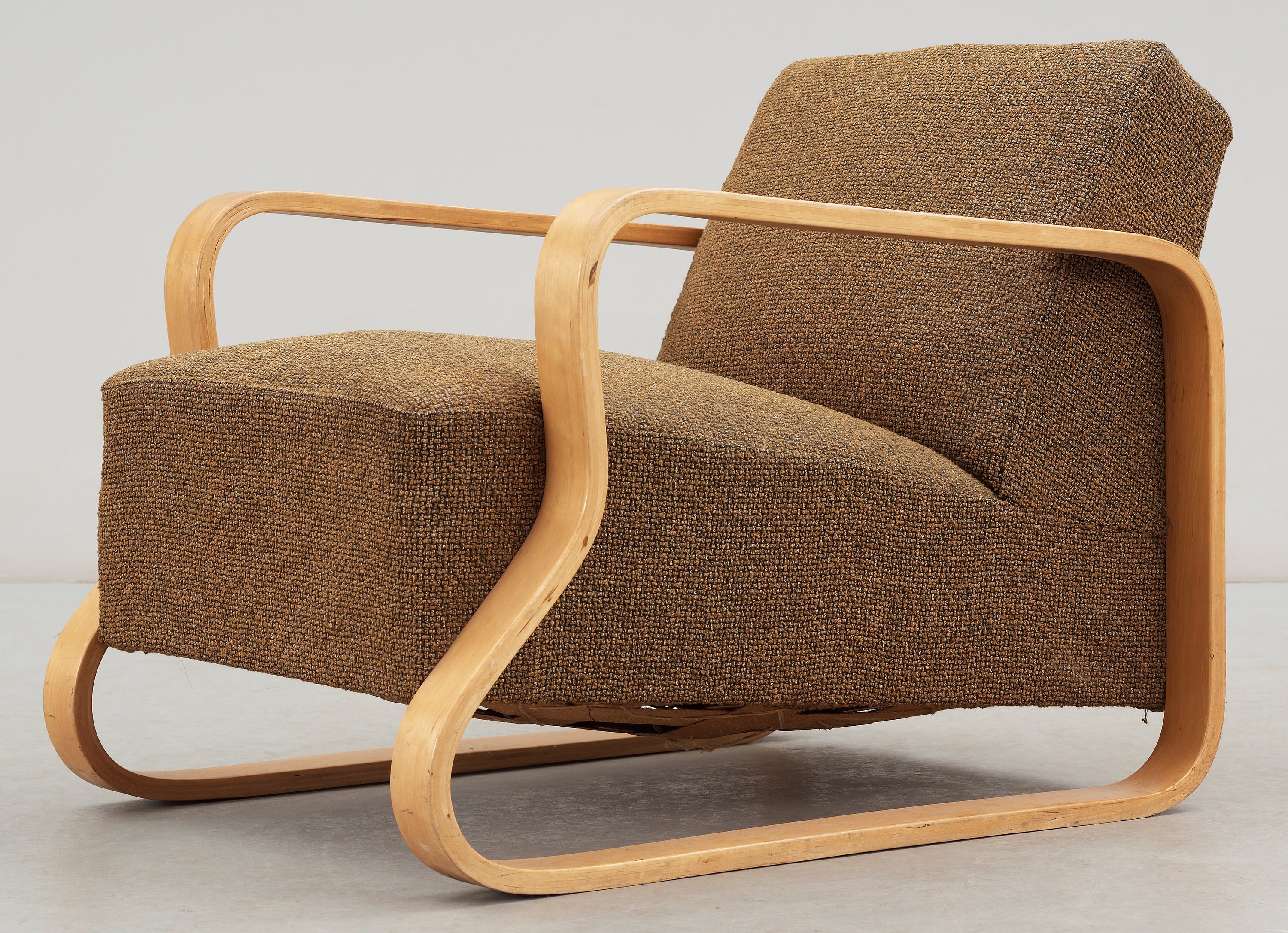 An Alvar Aalto laminated birch 'padded Paimio chair', upholstered in ...