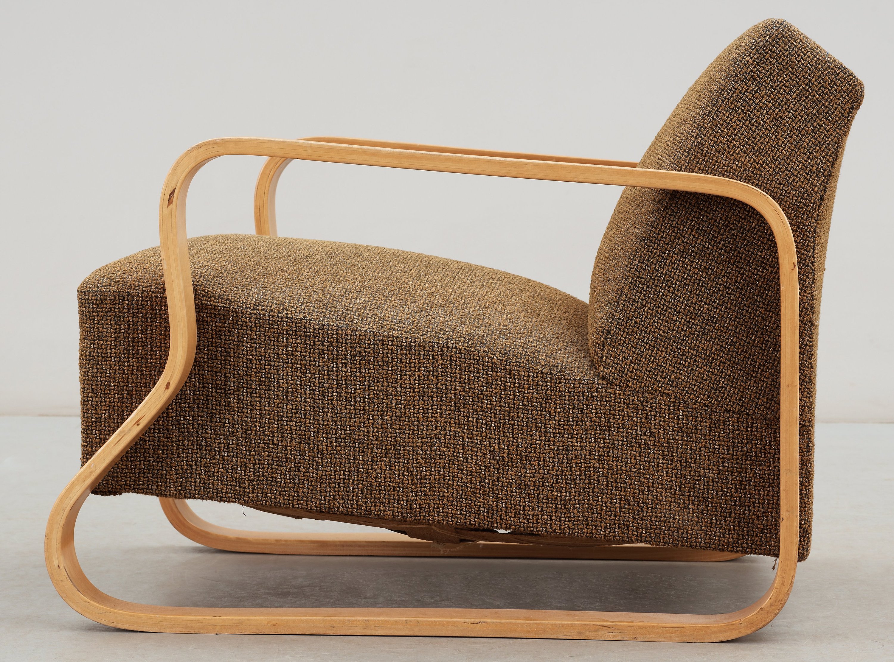 An Alvar Aalto laminated birch 'padded Paimio chair', upholstered in ...