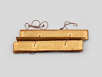 A palm-leaf manuscript bound between polychromed wooden boards, Sri ...
