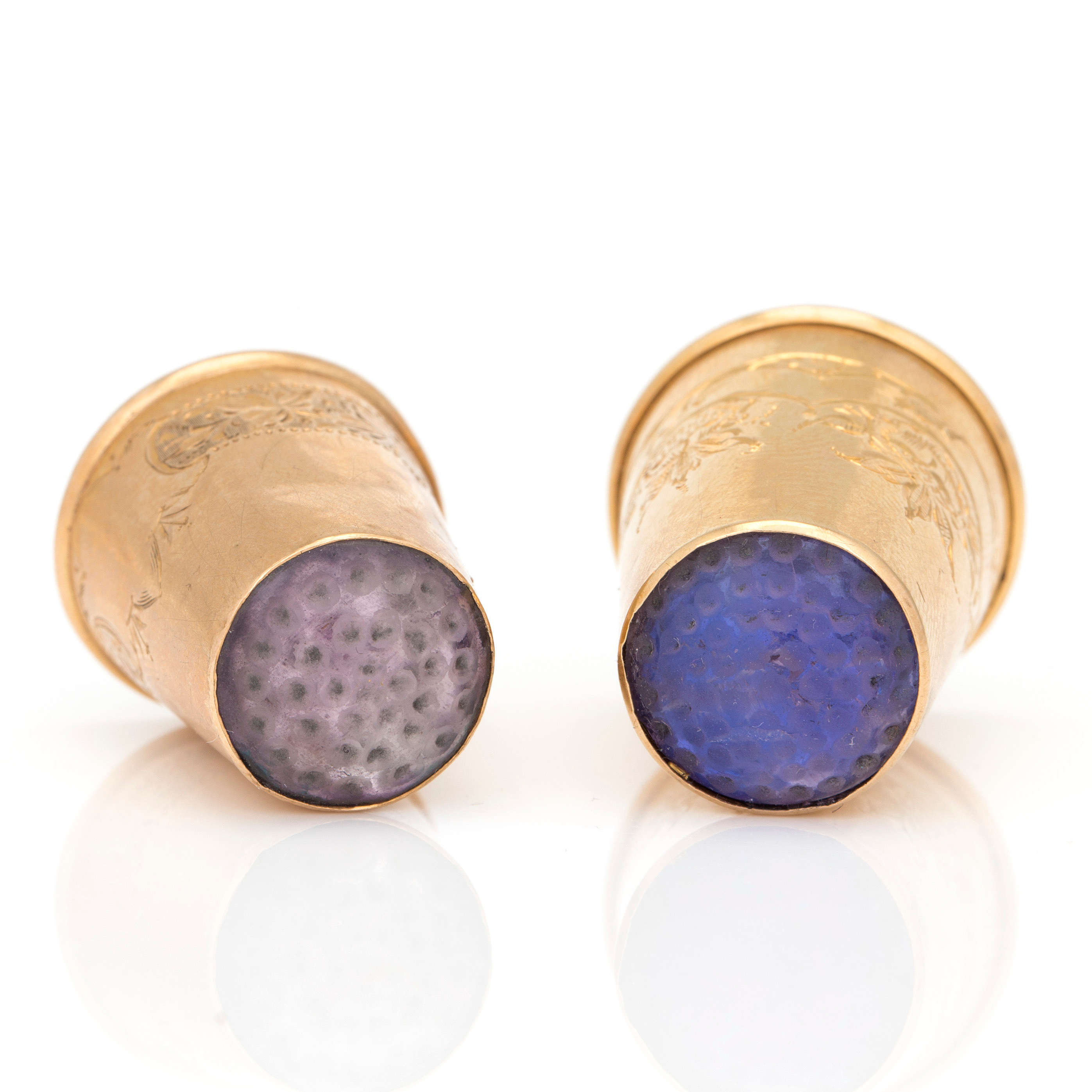 Two 18K gold thimbles with blue and lilac stones. - Bukowskis