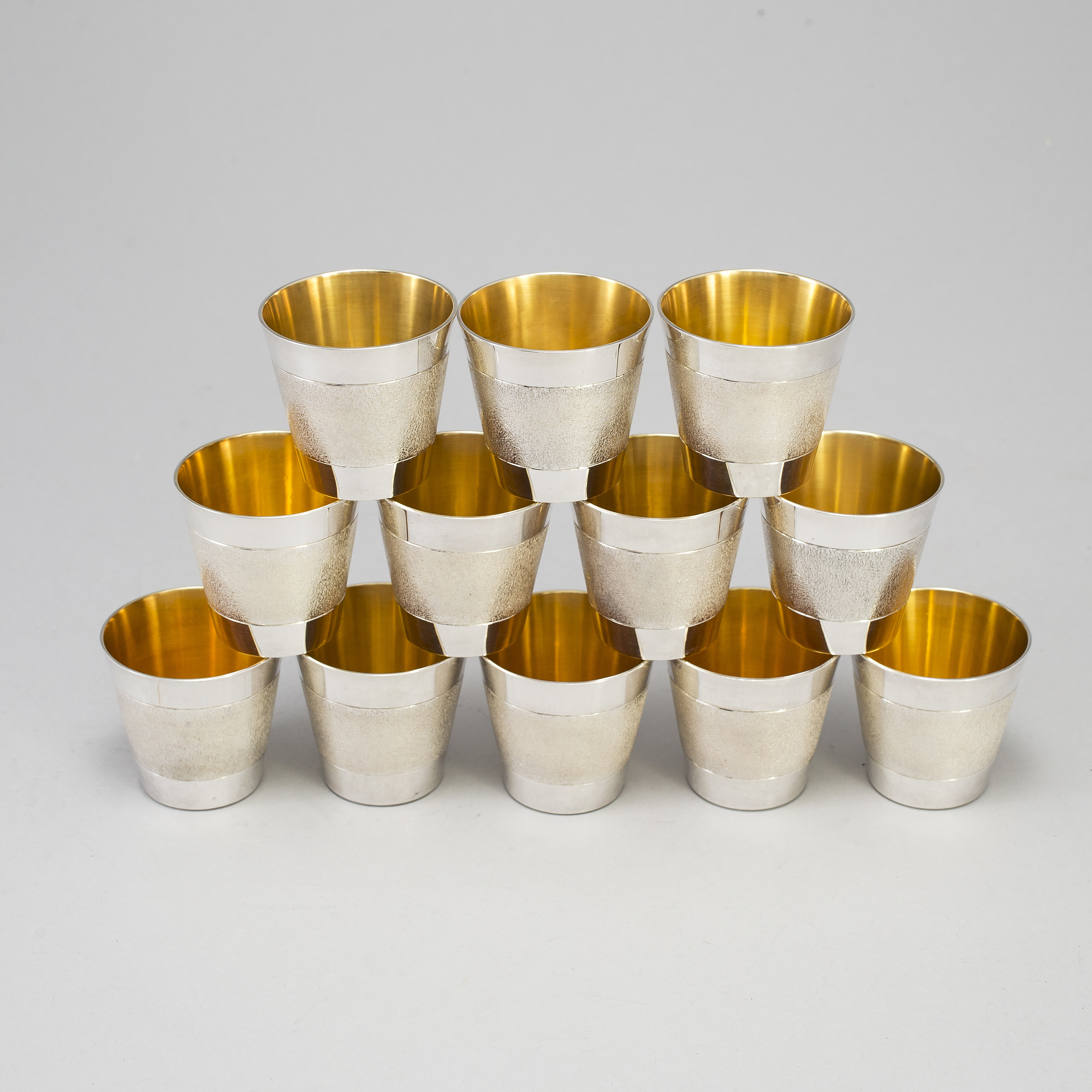 a set of twelve sterling silver partly gilded vodka cups by KE Palmberg ...