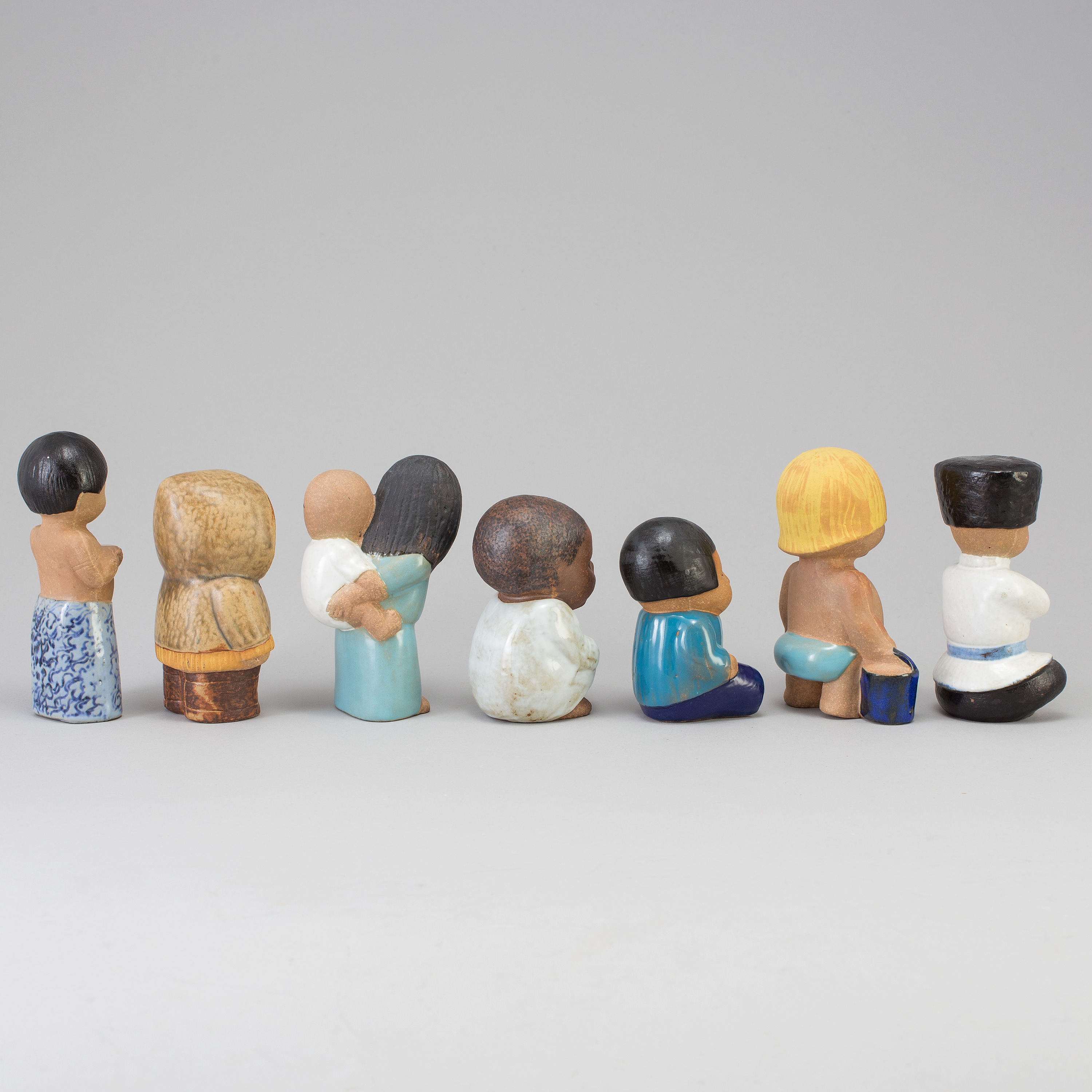 A collection of seven stonewear figurines from the series "All världens barn" by Lisa Larson for ...