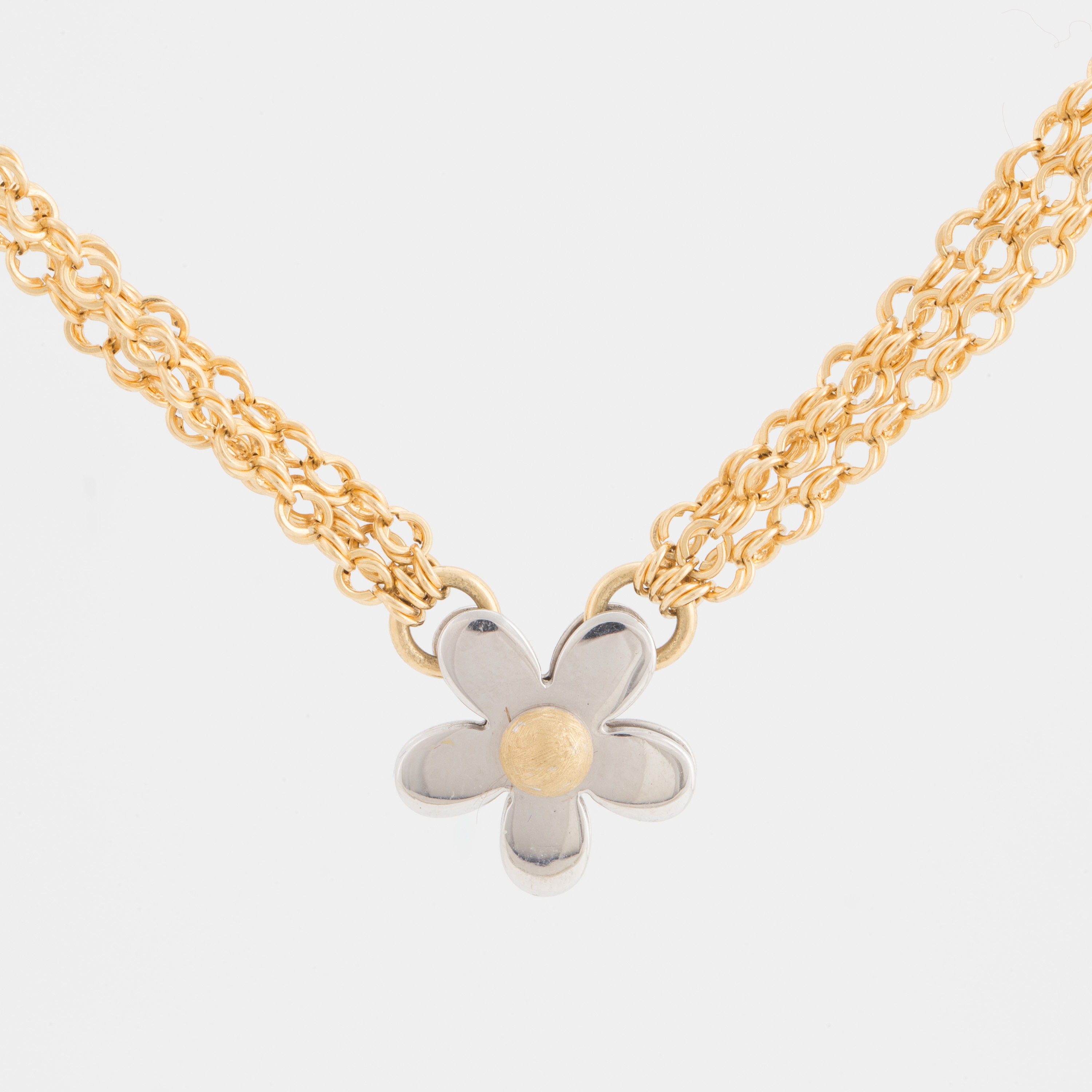 A three stranded chain necklace with a pendant in the shape of a flower ...