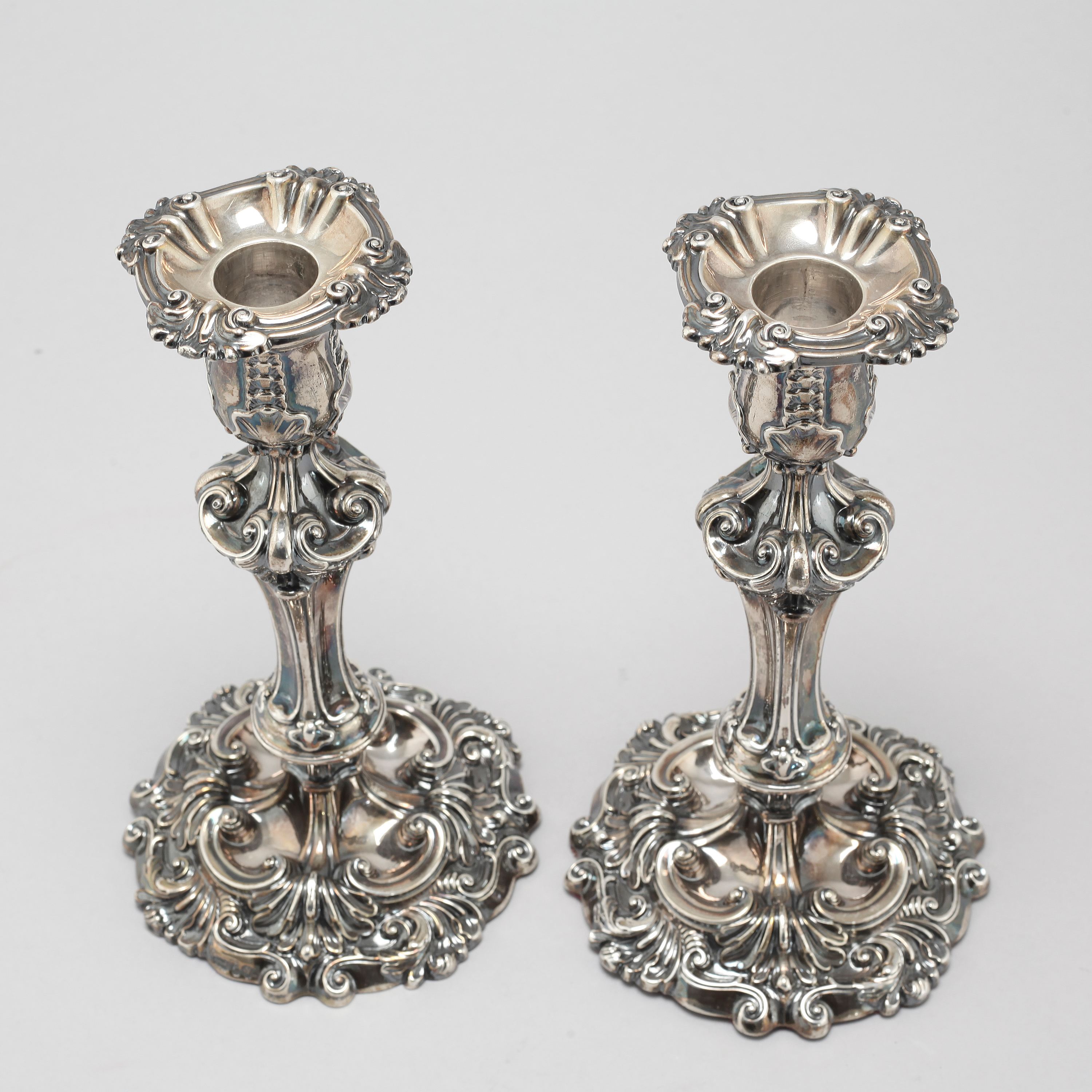 A pair of silver rococo style candlesticks from England, 19th century ...